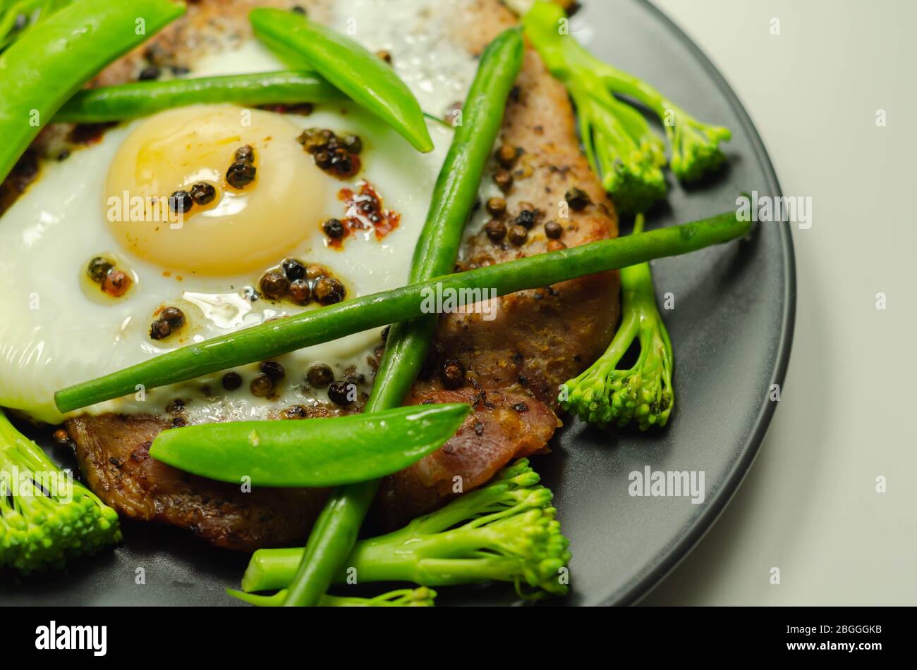 Fried portion of gammon served with egg, green beans, broccoli and ...