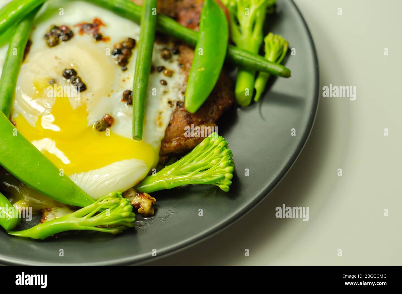 Fried portion of gammon served with egg, green beans, broccoli and ...