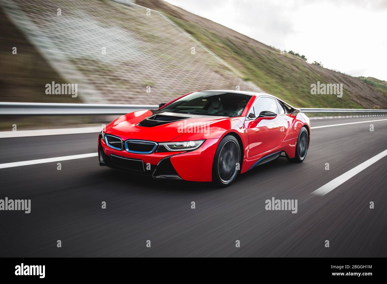 Red modern design car on the highlands driving in to the tunnel Stock ...