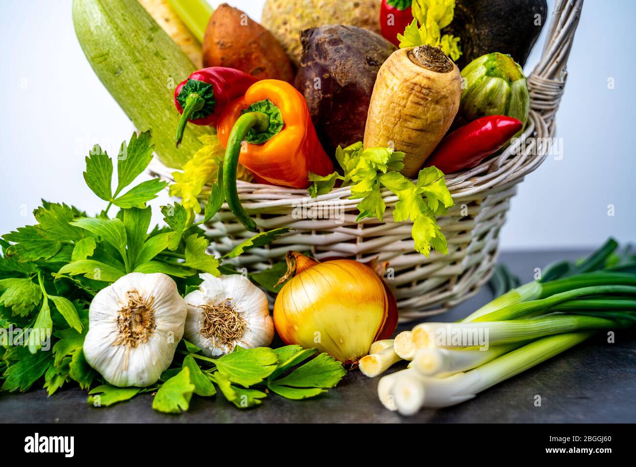 Fresh spring vegetables in basket on dark surface Stock Photo - Alamy