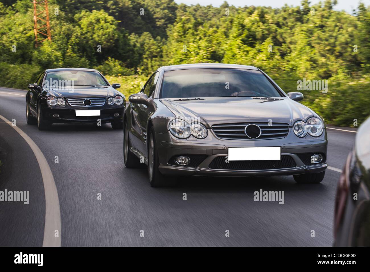 Silver supercar chasing other cars in the forest, front view Stock ...