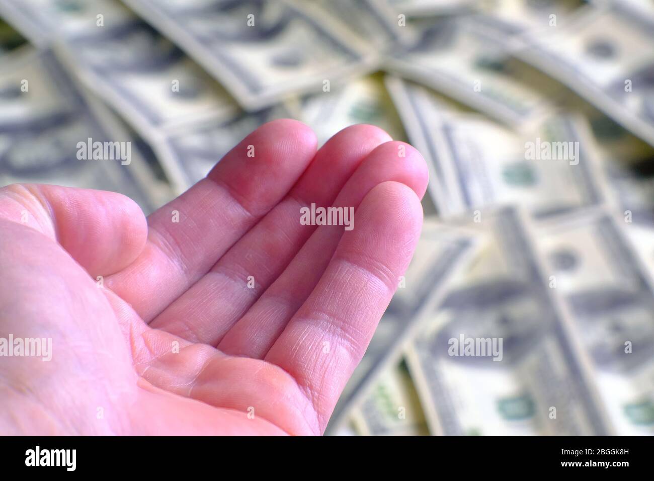 The begging hand on the background of dollar bills. An empty hand ...