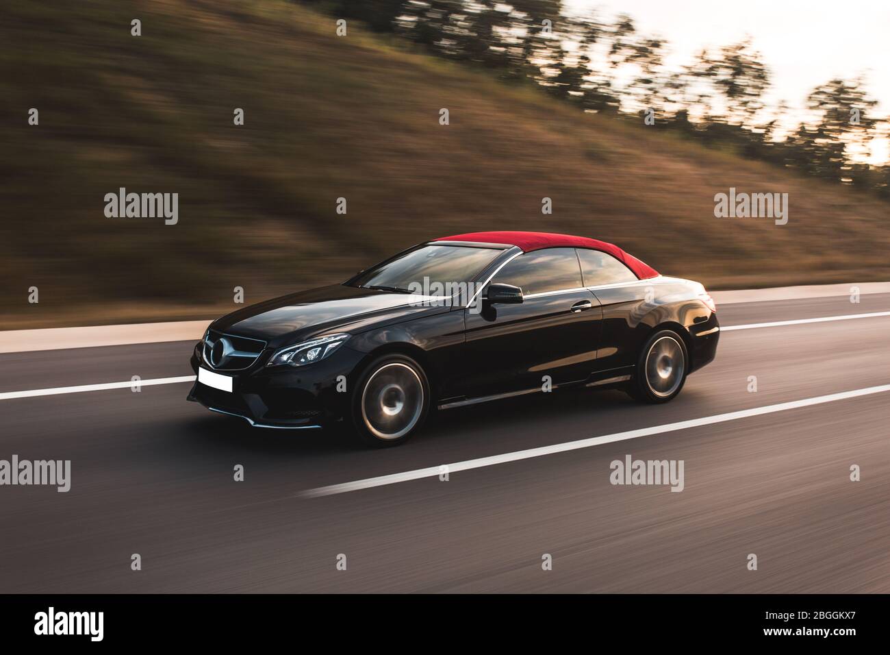 Black car with red tuning driving on the road, front view Stock Photo ...