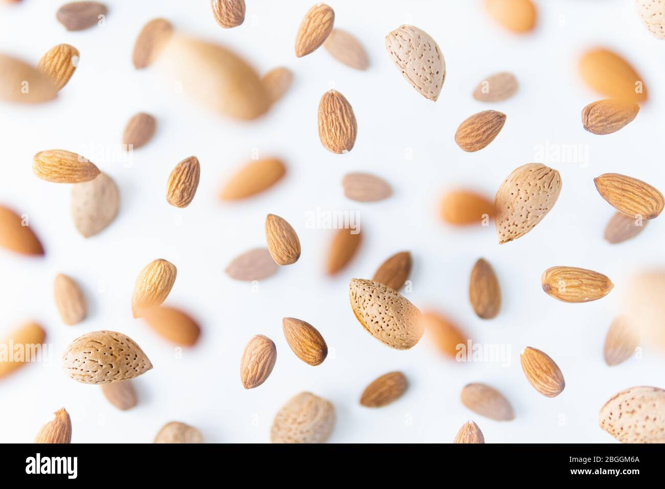 Shelled almond nuts flying above white background, levitation effect ...