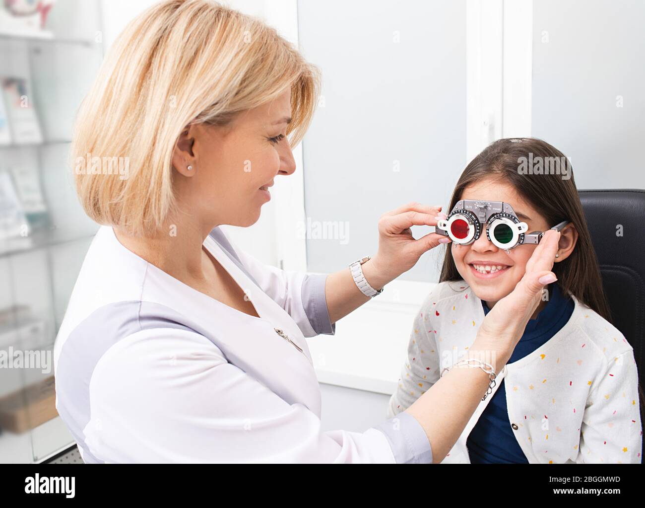 Child with optometrist trial frame in vision clinic. Optometrist ...