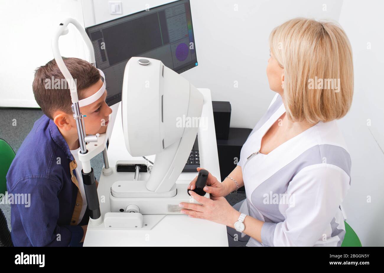Teenager boy in ophthalmology office. Diagnosis of eye anterior segment and tomography of boy ...