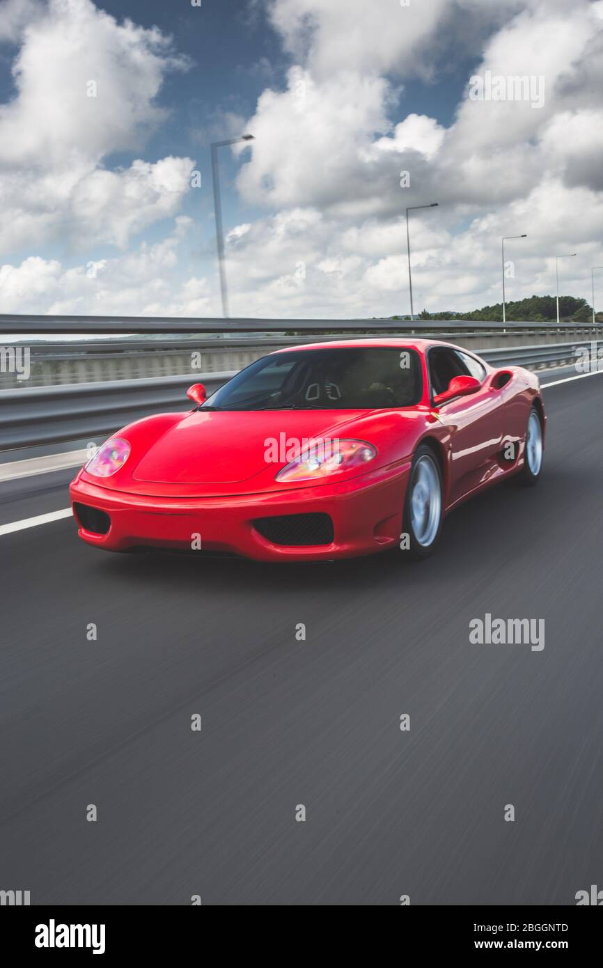 Red supercar racing on the highway under blue sky Stock Photo - Alamy