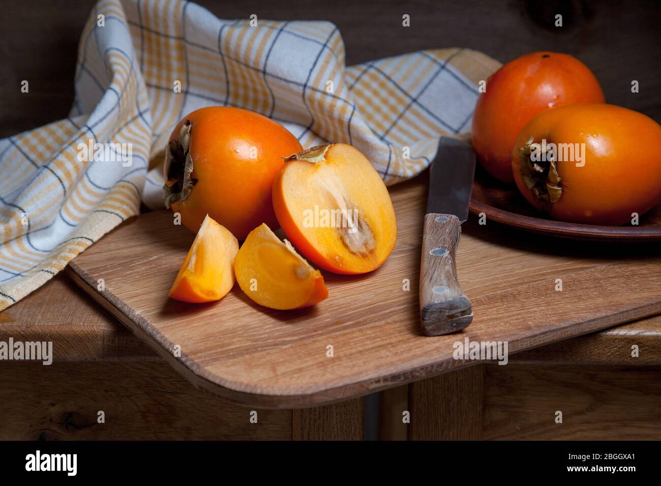 Composition of ripe delicious whole persimmon fruits, half and sliced ...