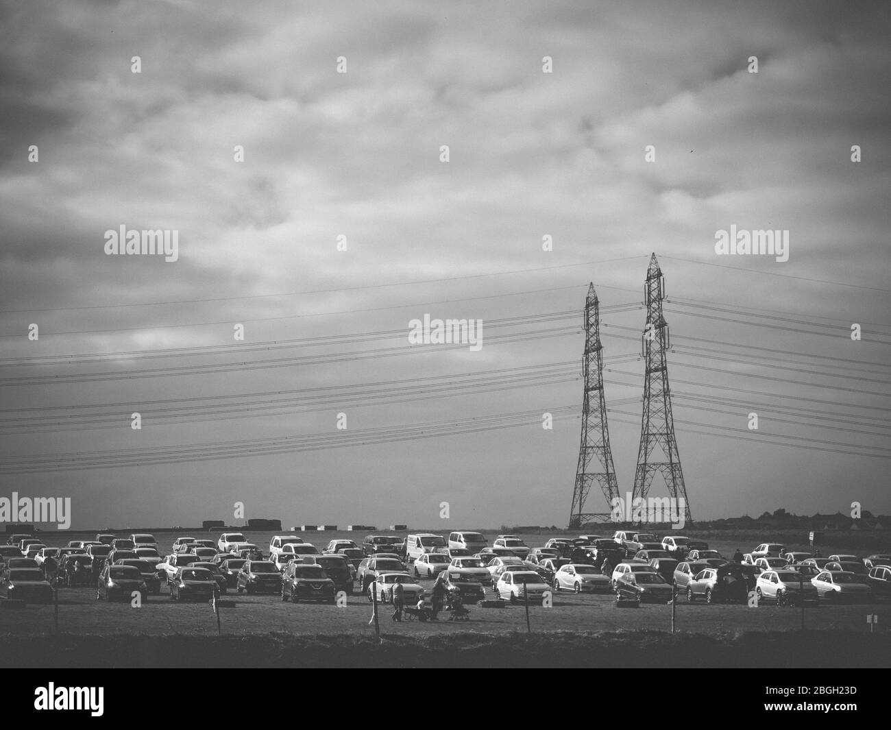 Multiple Cars Parked in Field with Electric Pylons in Background Stock ...