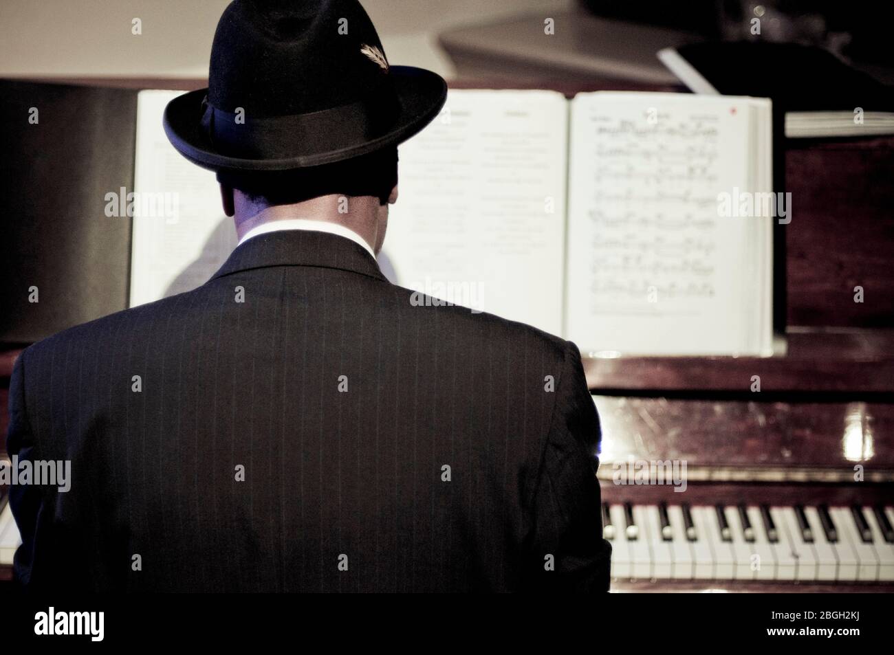 Rear View of Man playing Piano Stock Photo - Alamy