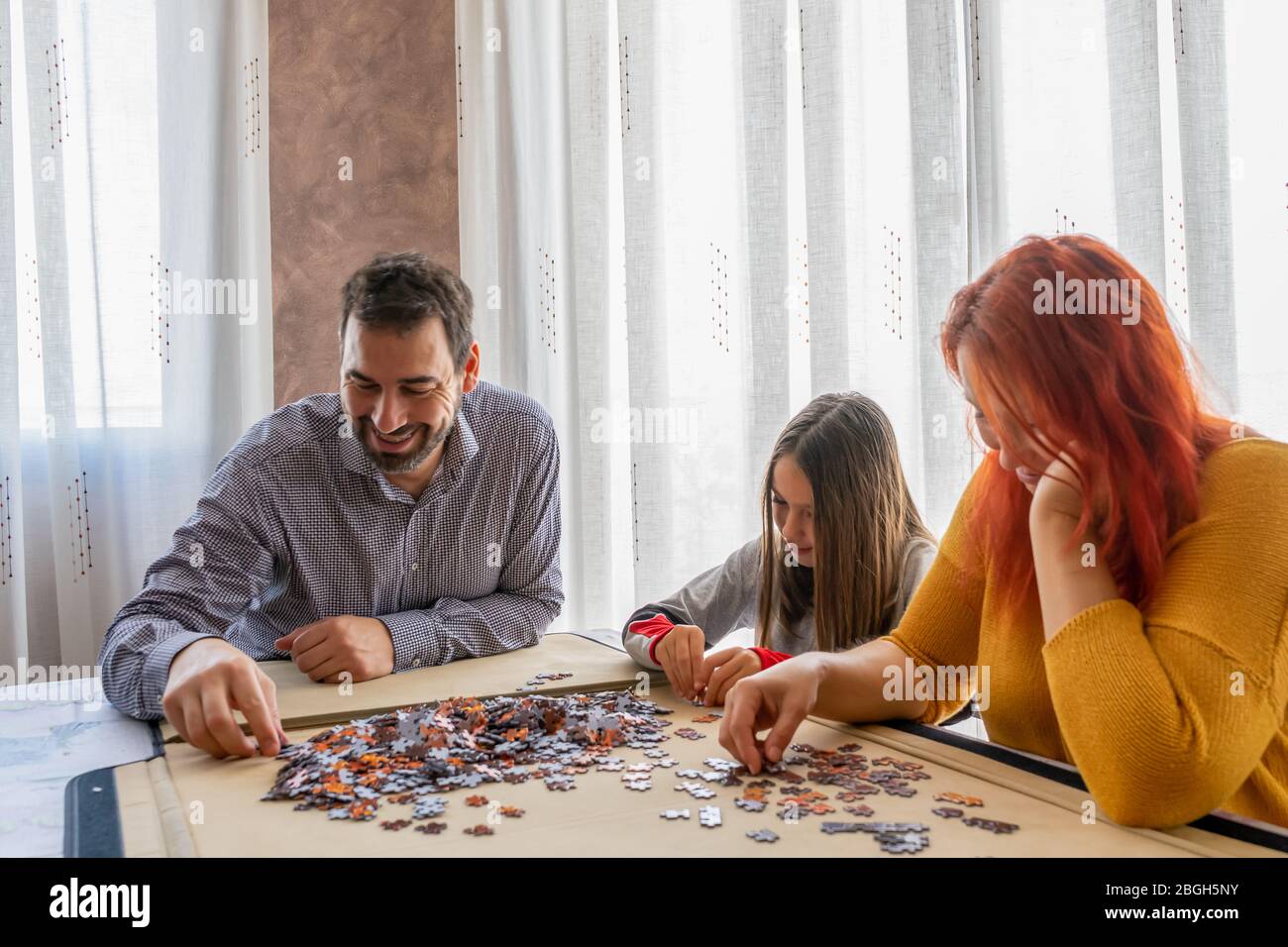 Family doing puzzle in the living room at home. Fun concept Stock Photo ...
