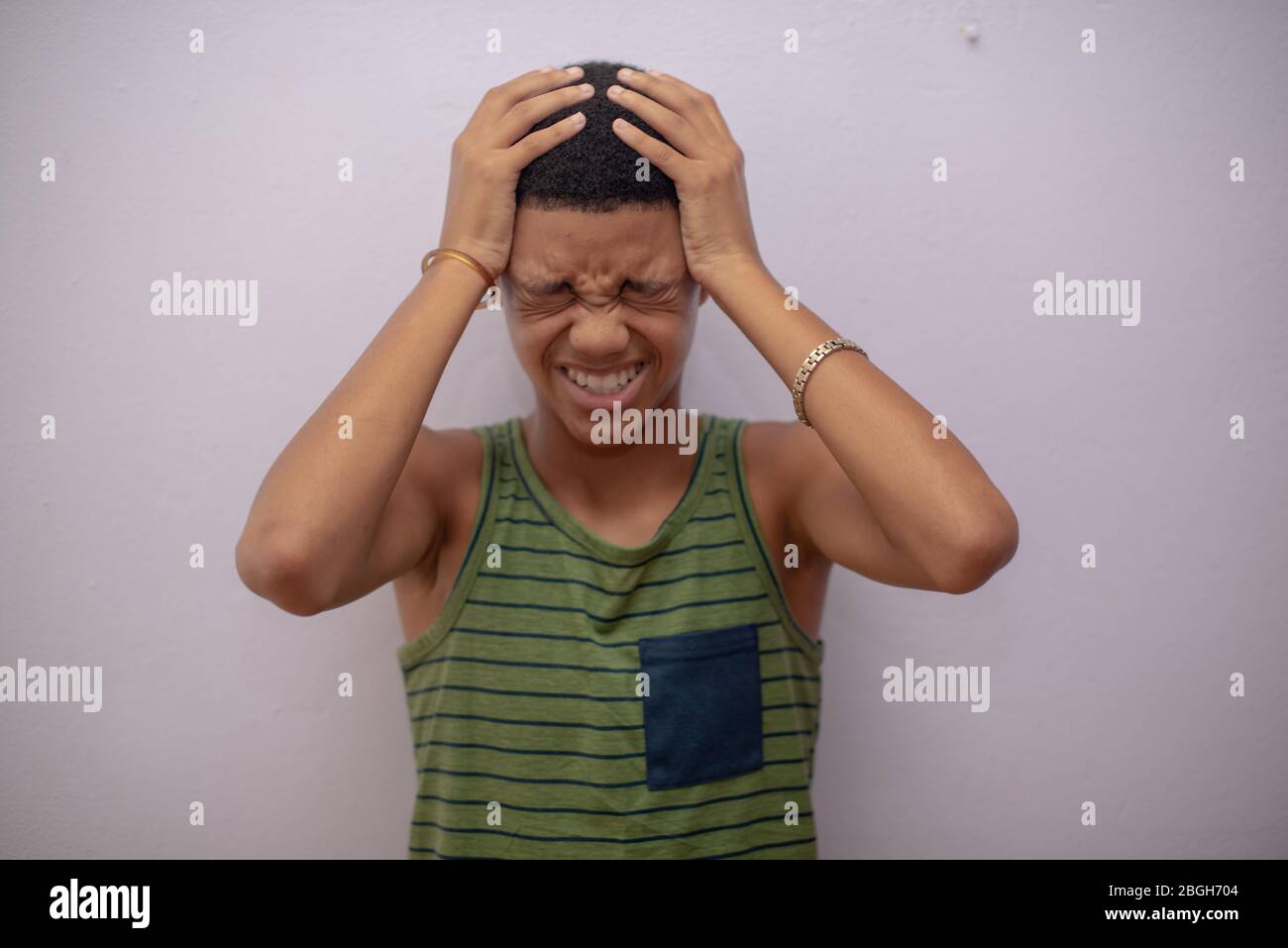 Young boy clutching his head Stock Photo - Alamy