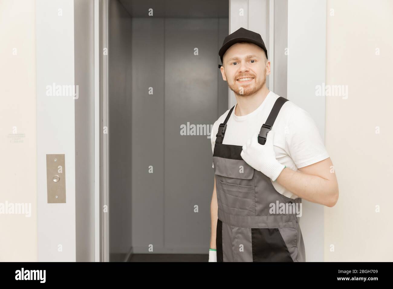 Lift machinist man repairing elevator fixing or adjusting mechanism ...