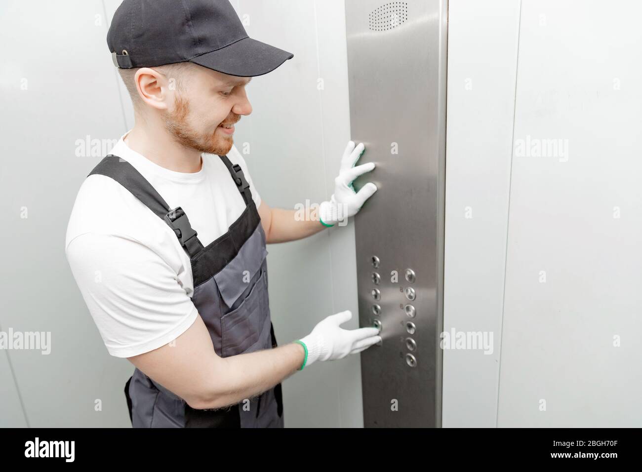 Lift machinist man repairing elevator fixing or adjusting mechanism ...