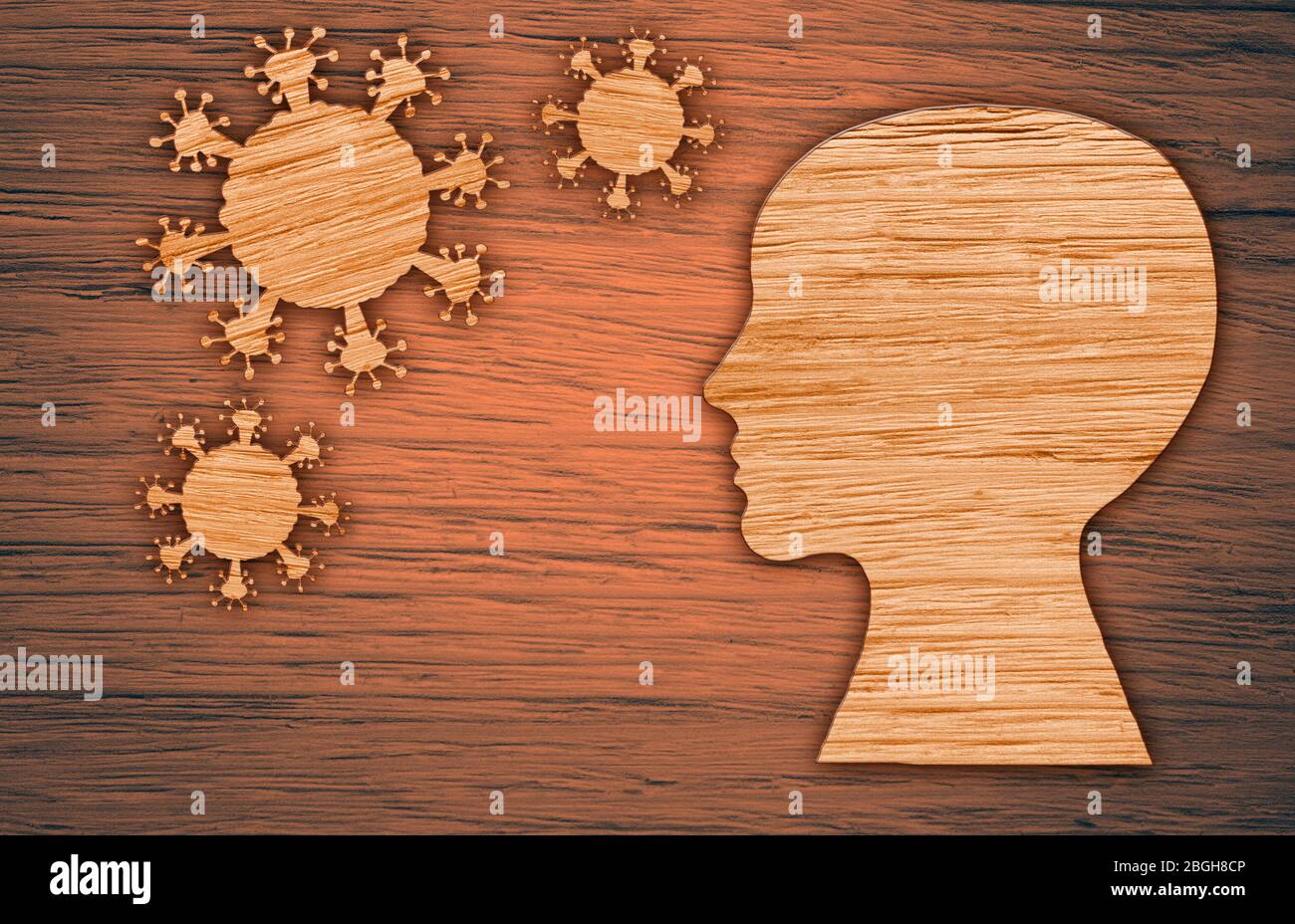 The silhouette of a human head, the virus on a brown wooden background ...