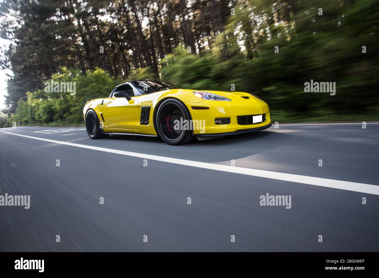 Yellow supercar speed motion through forest Stock Photo - Alamy