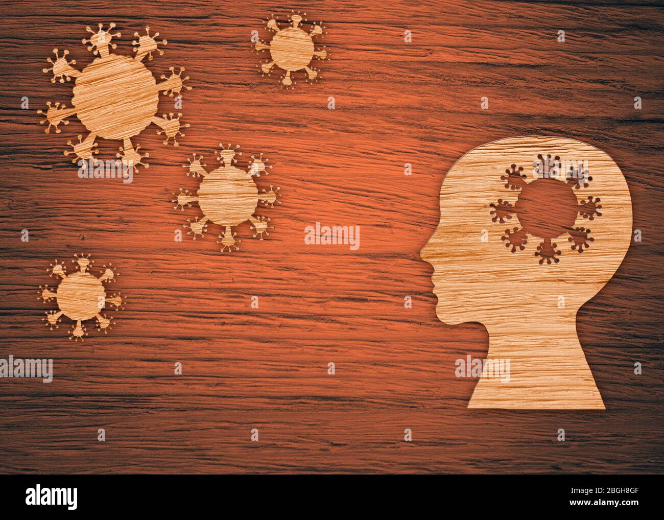 The silhouette of a human head, the virus on a brown wooden background ...