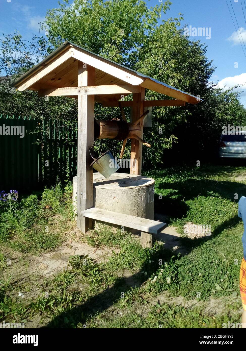 A new cottage well with a bucket and a roof Stock Photo - Alamy