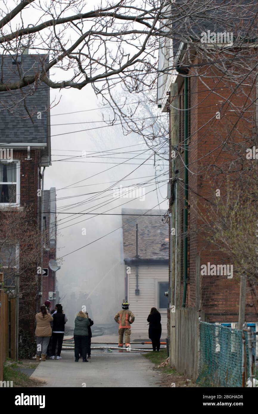 Heavy white smoke rising from house fire in the day time as people ...
