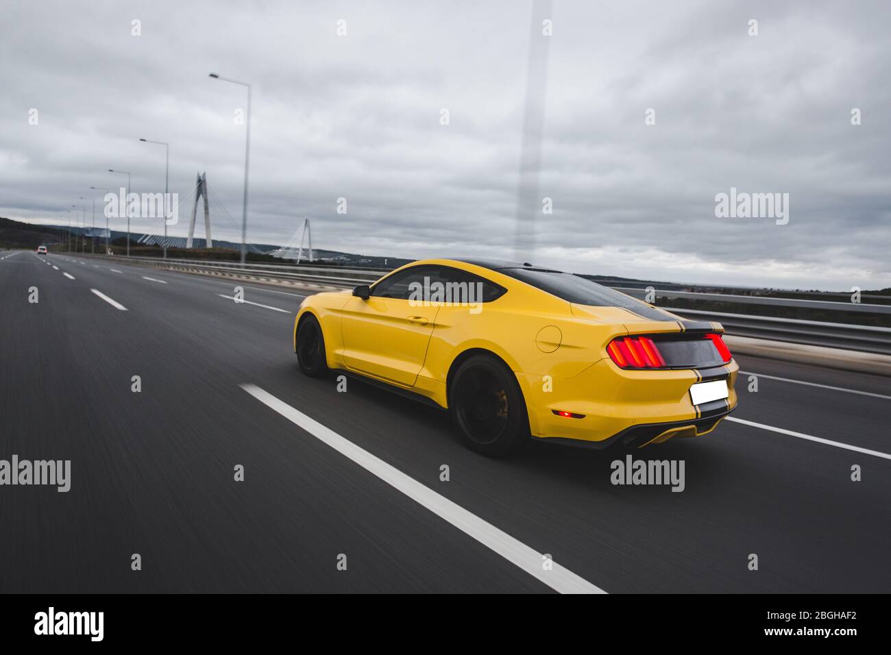 Yellow sport car in the racing track over the landscapes Stock Photo ...