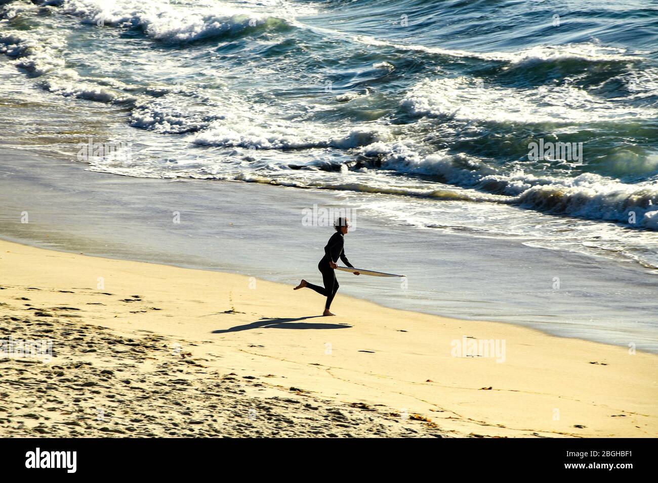Skimboarder begins on the beach and runs into the surf Stock Photo - Alamy
