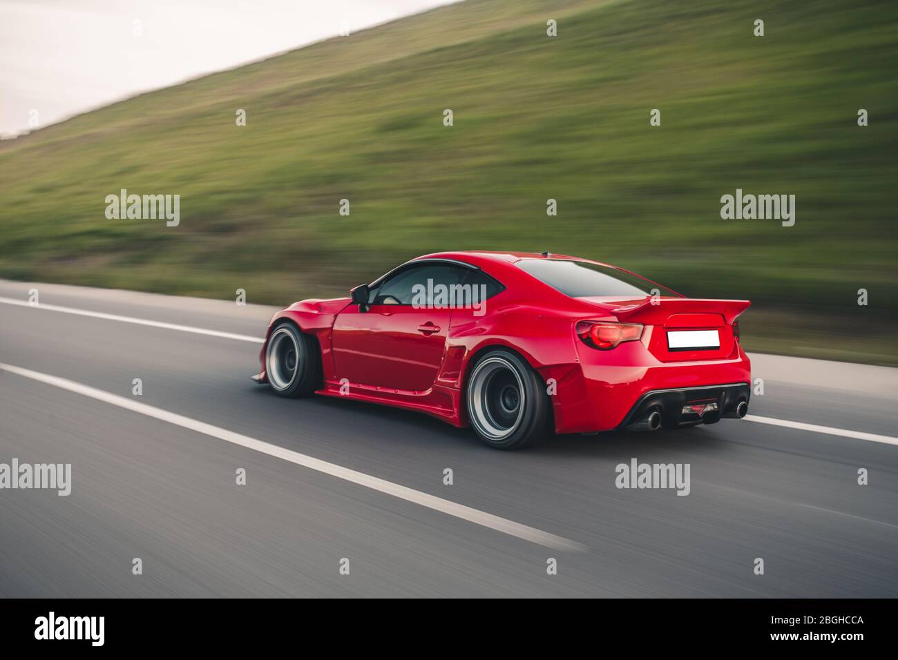 Red elegant sport car landscape driving in green highlands Stock Photo ...