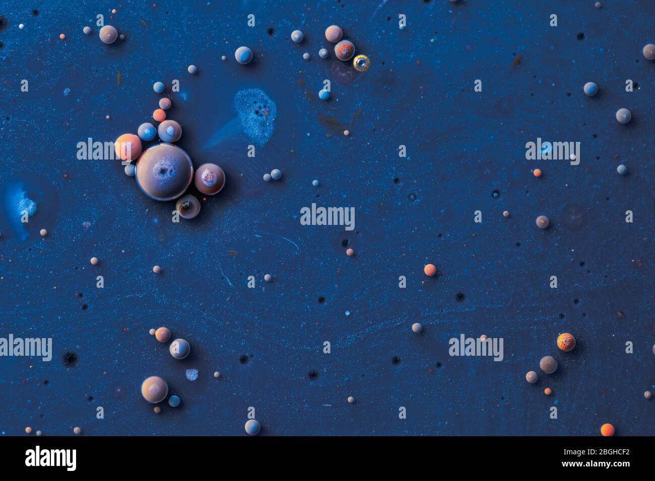 Color drops floating in oil and water over a colorful underground with ...