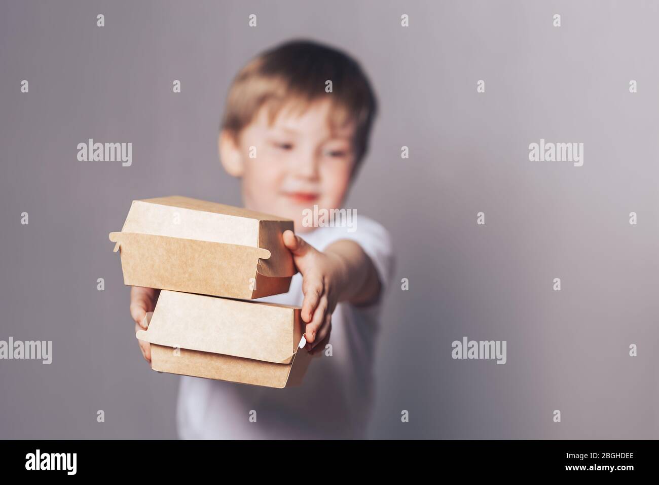 Beautiful little boy holding boxes in hands Stock Photo - Alamy