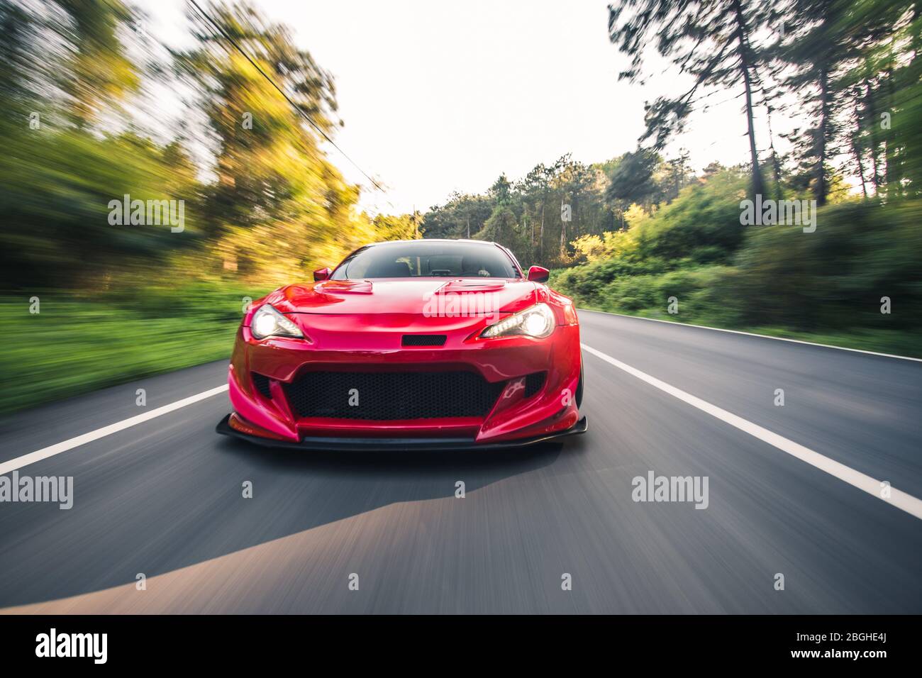 Superpower red racing car on the landscape drive, front view Stock ...