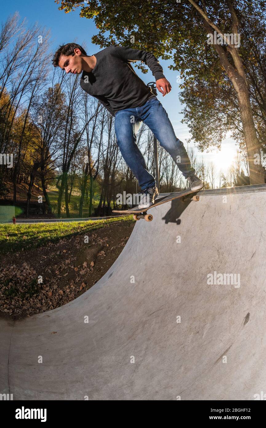 Skateboarder dropring a ramp at sunset at the local skatepark Stock ...