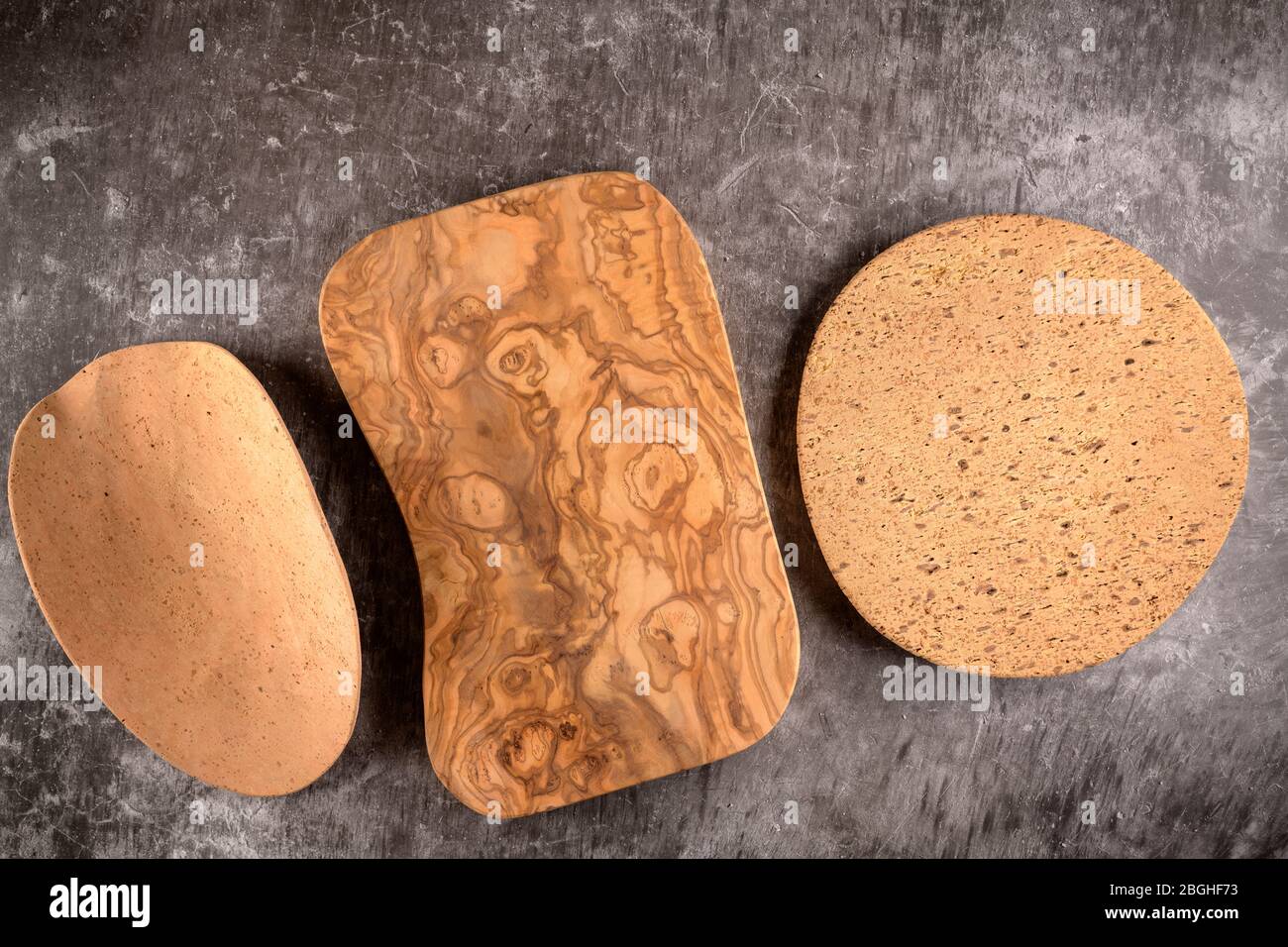 Top view of Two cork plates and wood board on dark grey countertop ...