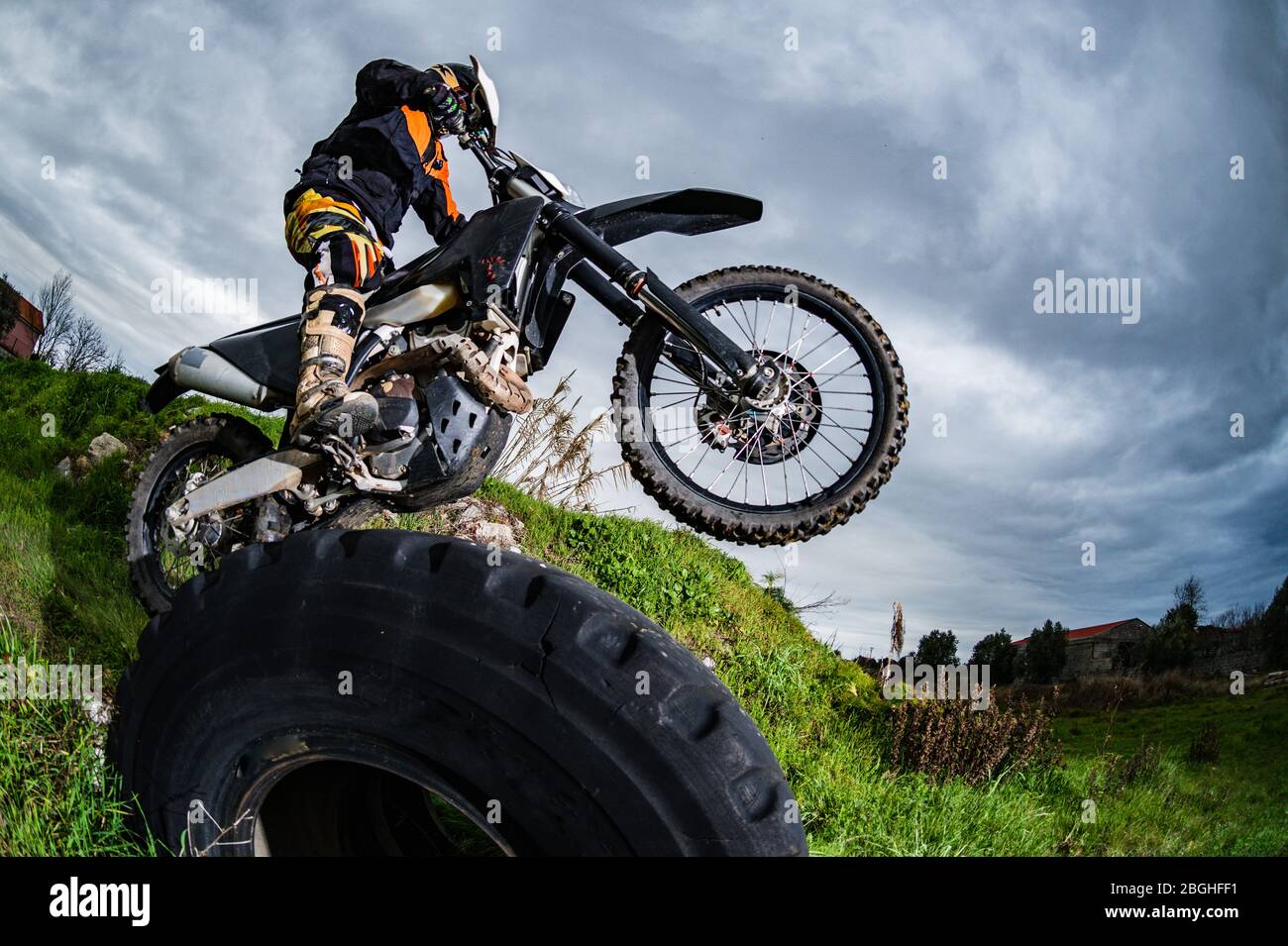Enduro bike rider in action. Obstacle overcome on mud and grass terrain ...