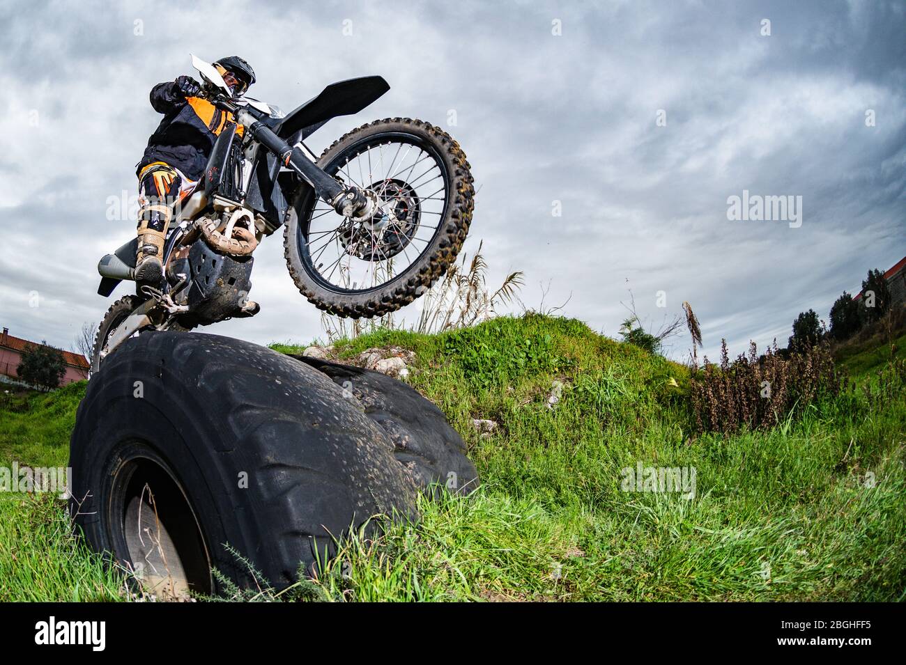 Enduro bike rider in action. Obstacle overcome on mud and grass terrain ...