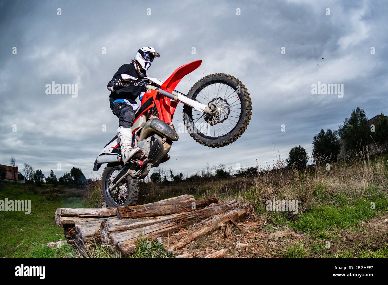 Enduro bike rider in action. Obstacle overcome on mud and grass terrain ...