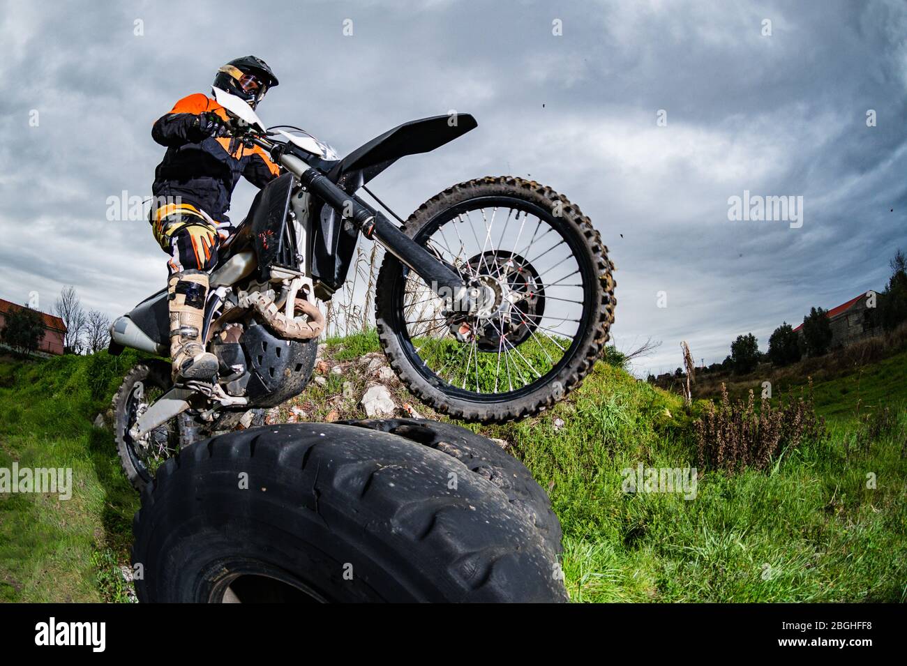 Enduro bike rider in action. Obstacle overcome on mud and grass terrain ...