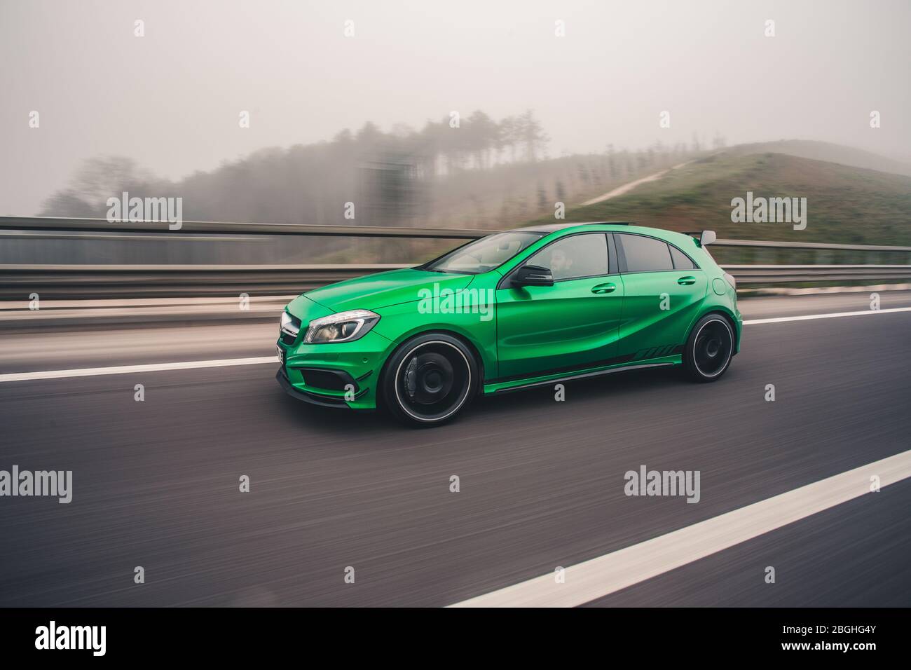 Green racing car, performance autoshow in the foggy weather Stock Photo ...