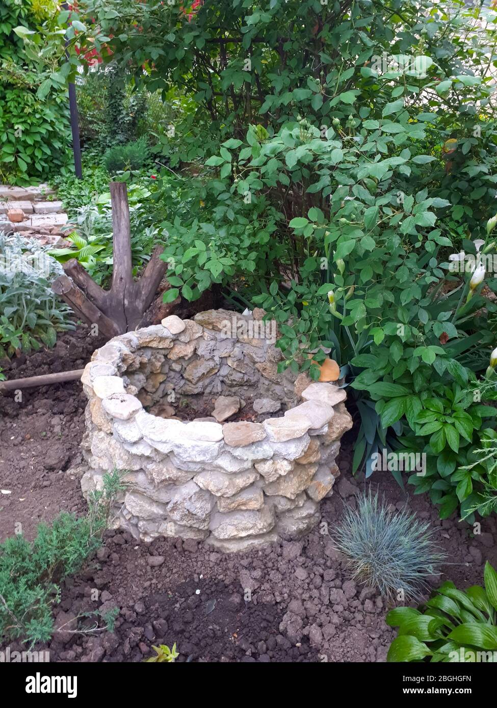 Well, made of stones and cement in the garden under the bush Stock ...
