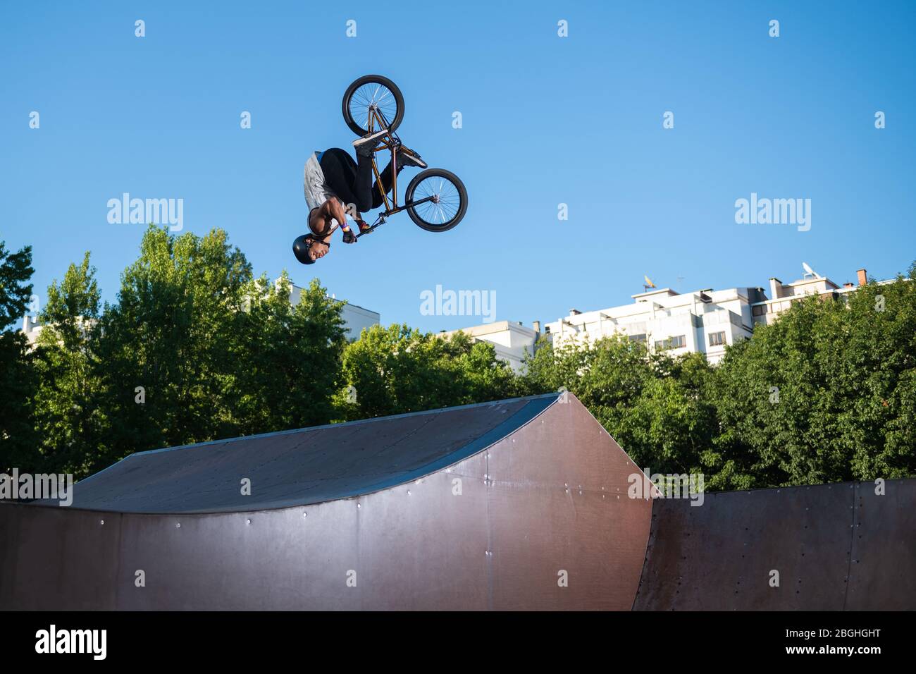 Biker jump high from jump box ramp performing dangerous backflip trick ...