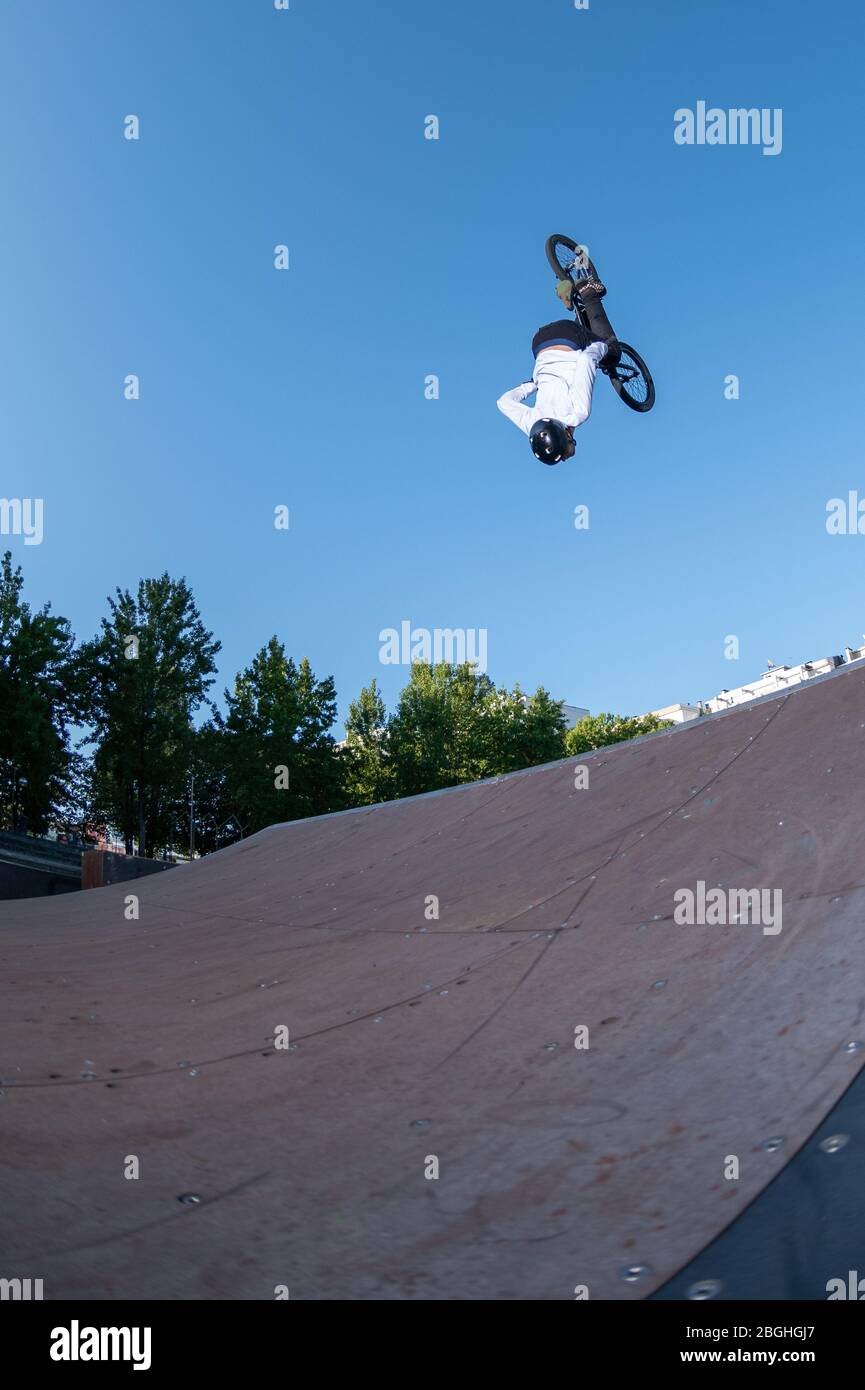 Biker jump high from jump box ramp performing dangerous backflip trick ...