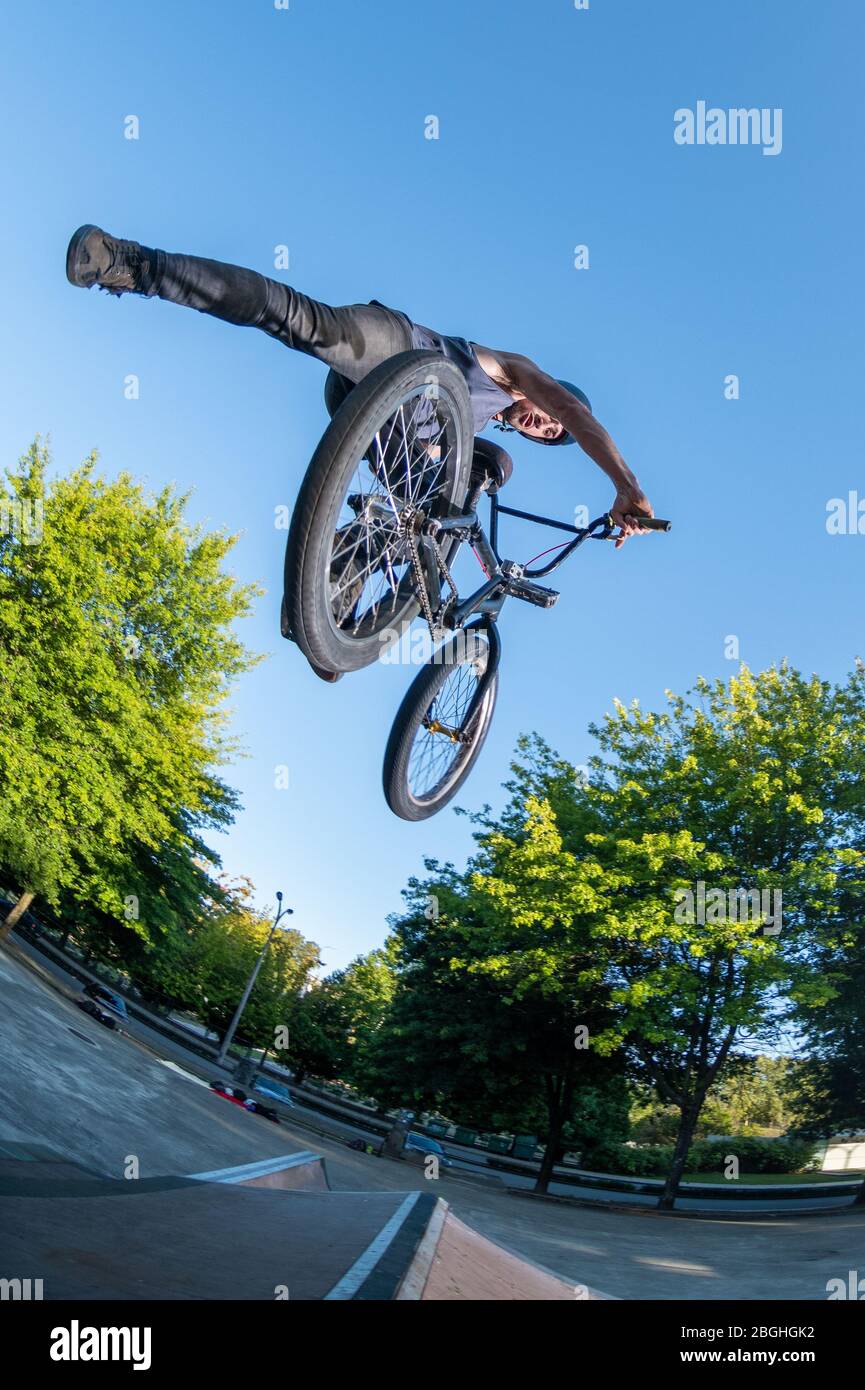 Biker jump high from jump box ramp performing foot off trick Stock ...