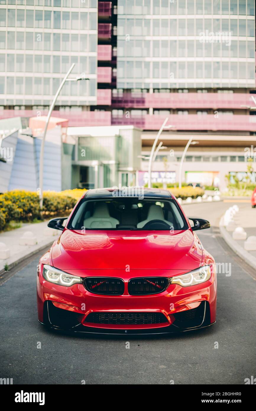 Red universal sedan touring in the city streets Stock Photo - Alamy