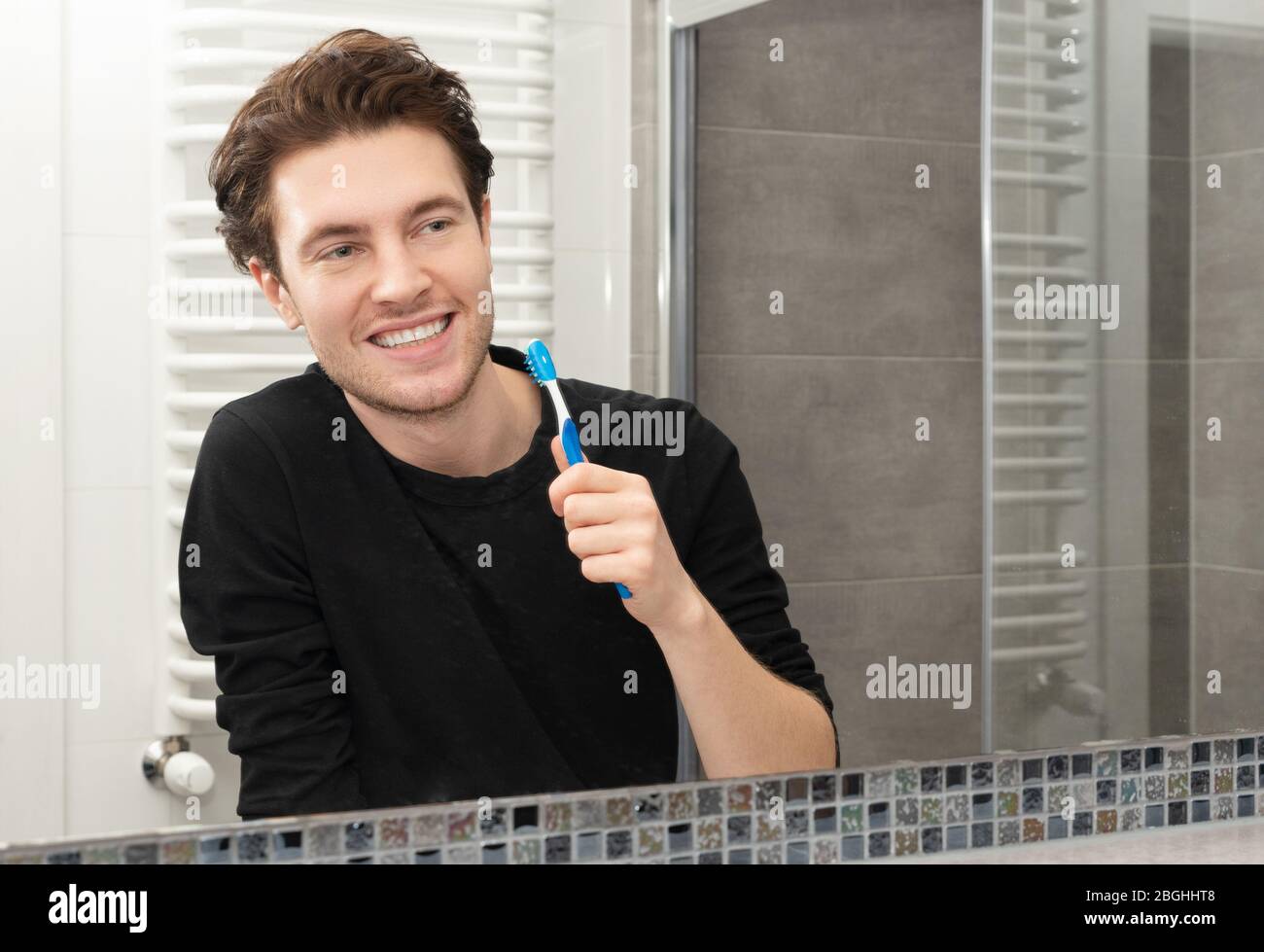 Man brushing teeth in bathroom. Dental health concept Stock Photo - Alamy