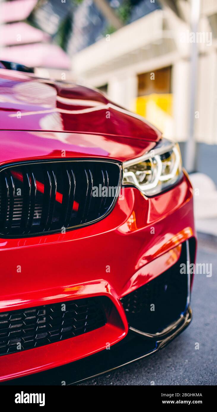 Red model sedan in the landmark parking, front light and bumper view ...