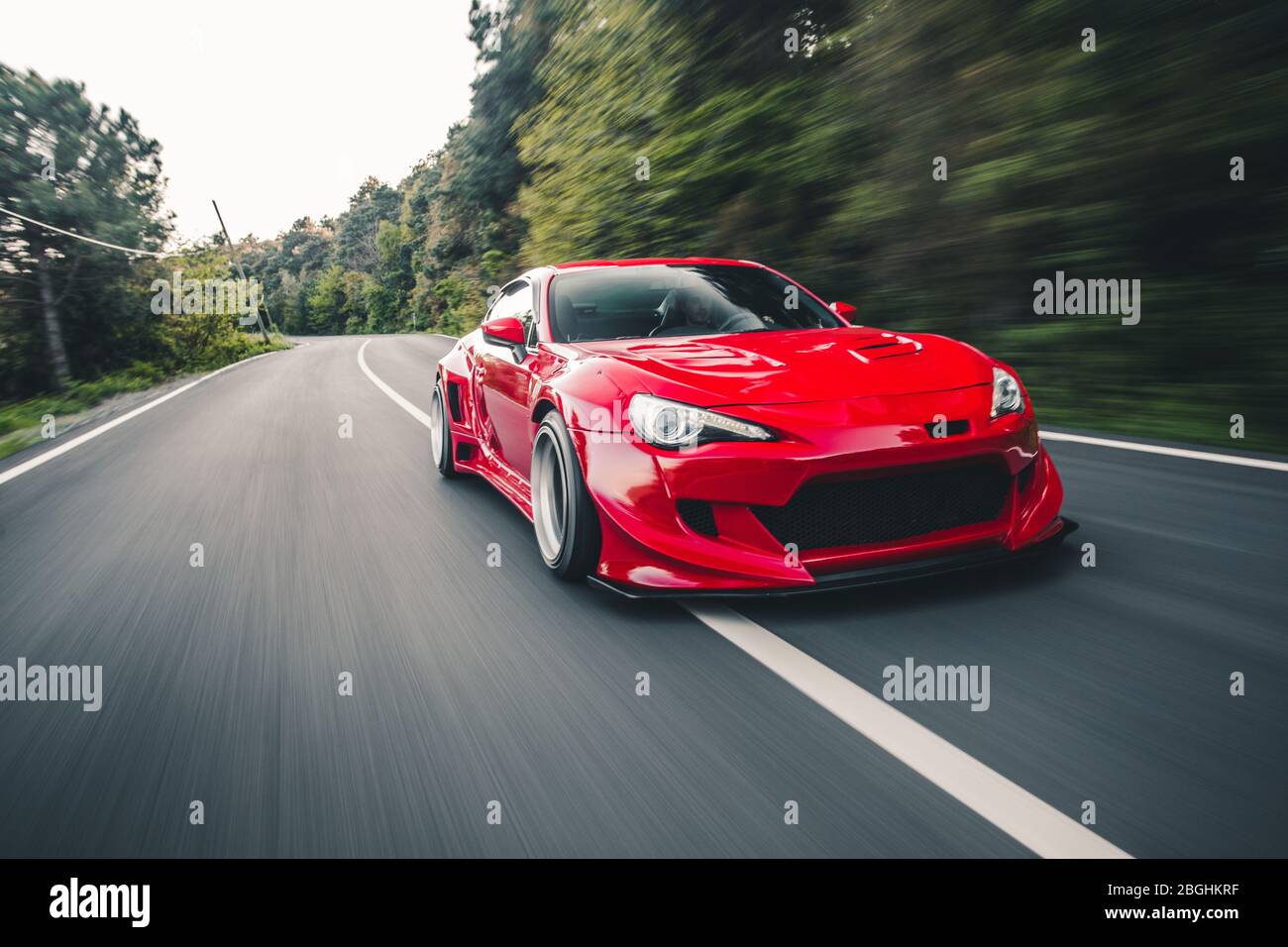 Superpower red racing car on the landscape drive through rain forests ...