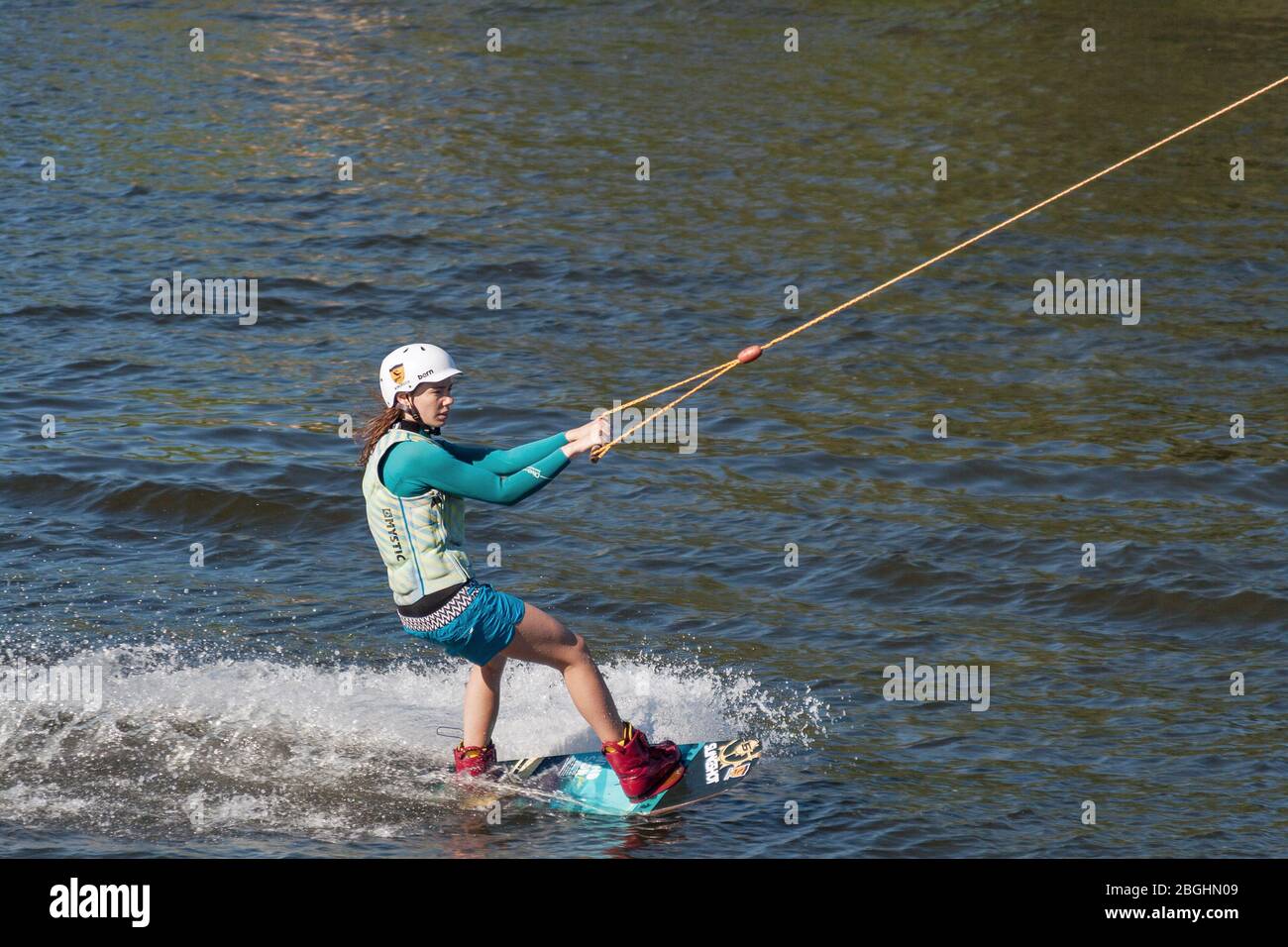 KYIV, UKRAINE - JUNE 05, 2015: Young woman wakesurfing at cables wake ...