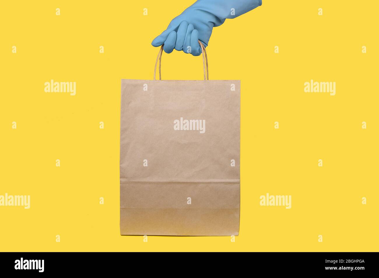 Close up female holds in hand brown clear empty blank craft paper bag ...