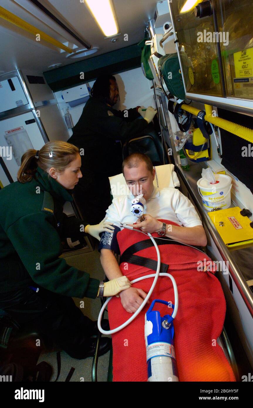 A paramedic monitors her patients oxygen breathing Stock Photo - Alamy