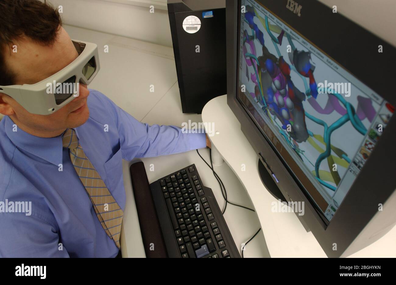 A biochemist wearing special glasses observes a 3D molecular model ...