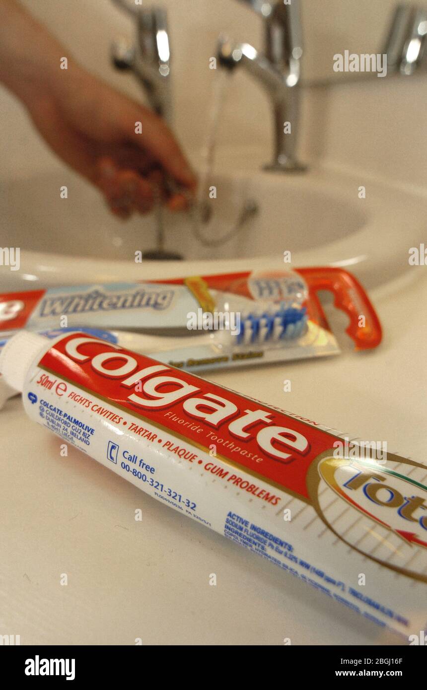 A tube of Colgate toohpaste being used in a bathroom Stock Photo - Alamy
