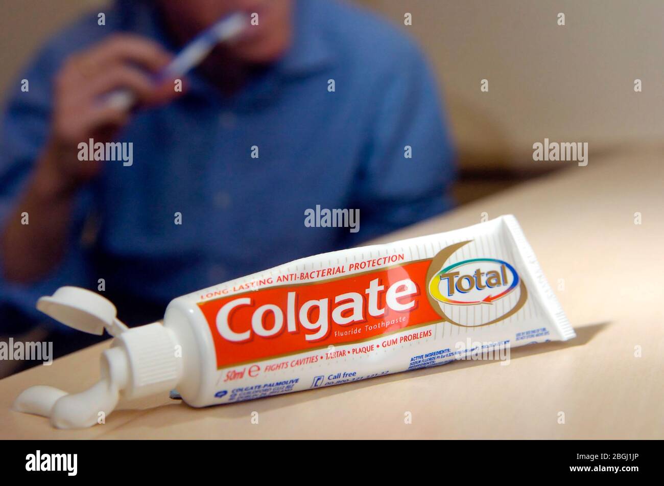 A tube of Colgate toohpaste being used in a bathroom Stock Photo - Alamy